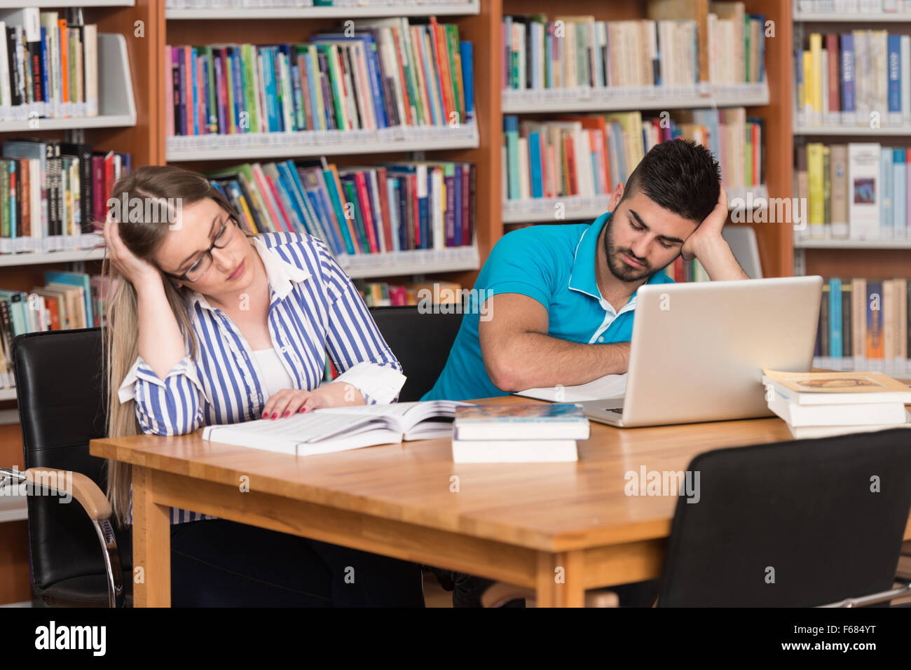 Stressed Students In High School Sitting At The Library Desk - Shallow ...