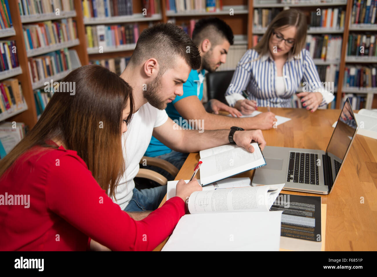 In The Library - Handsome Group Of Students With Laptop And Books ...