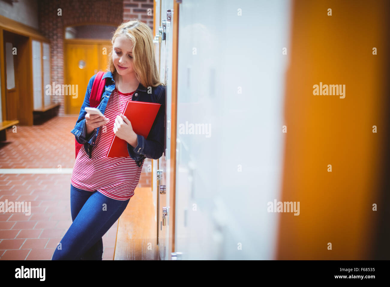 Smiling student leaning against locker hi-res stock photography and ...