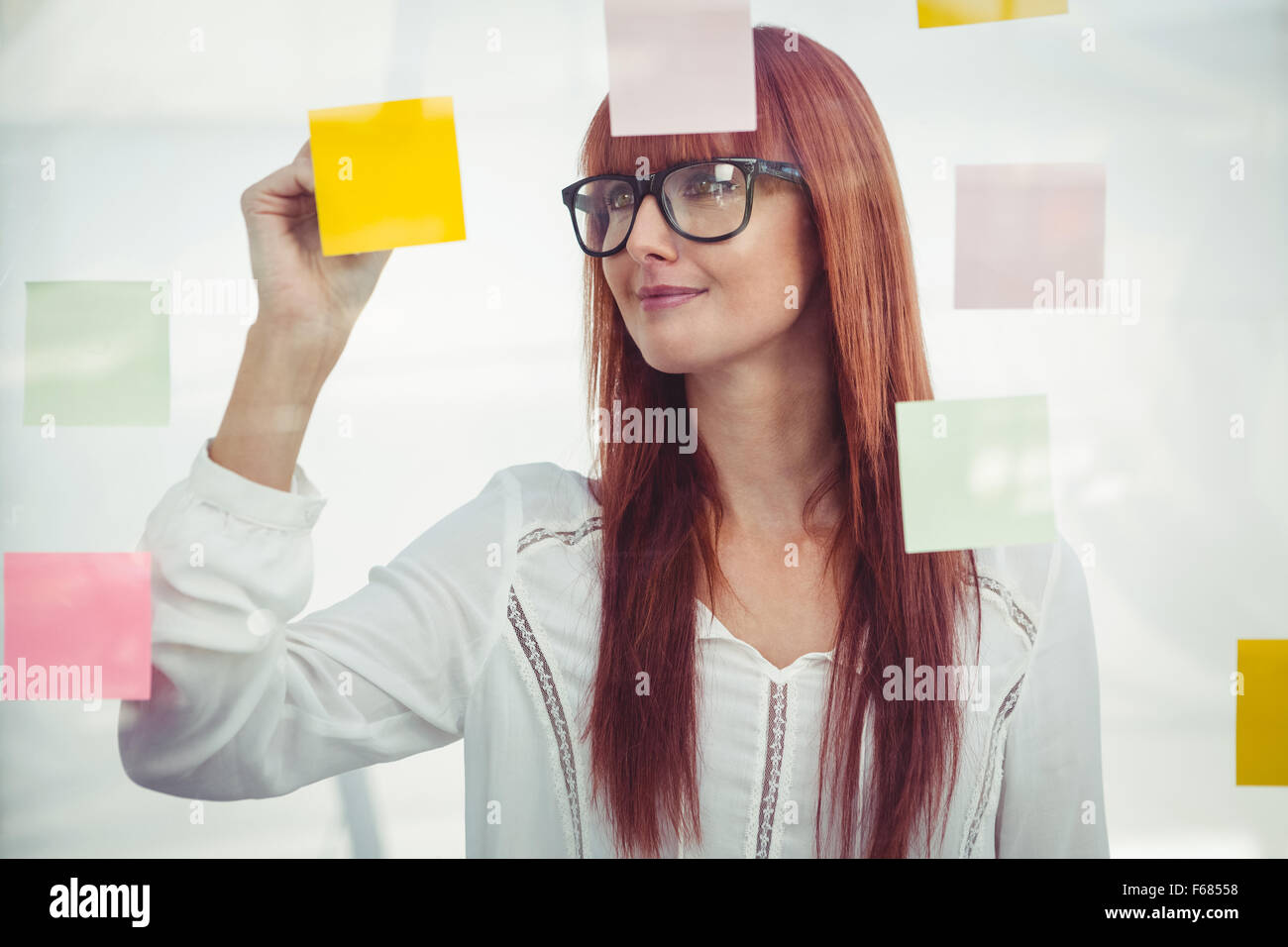 Attractive hipster woman writing on sticky notes Stock Photo - Alamy