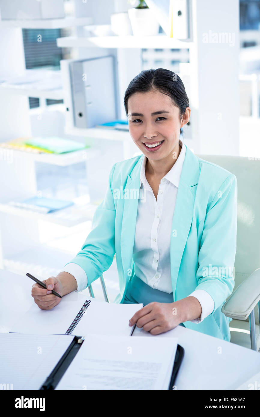Smiling businesswoman writing into a notepad Stock Photo - Alamy