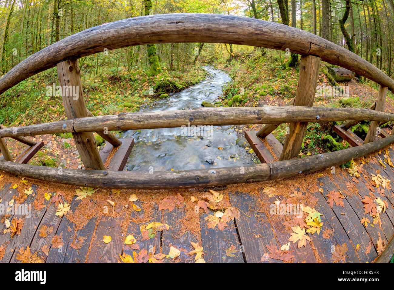 Unique view of a creek through a wood bridge hand rail Stock Photo - Alamy