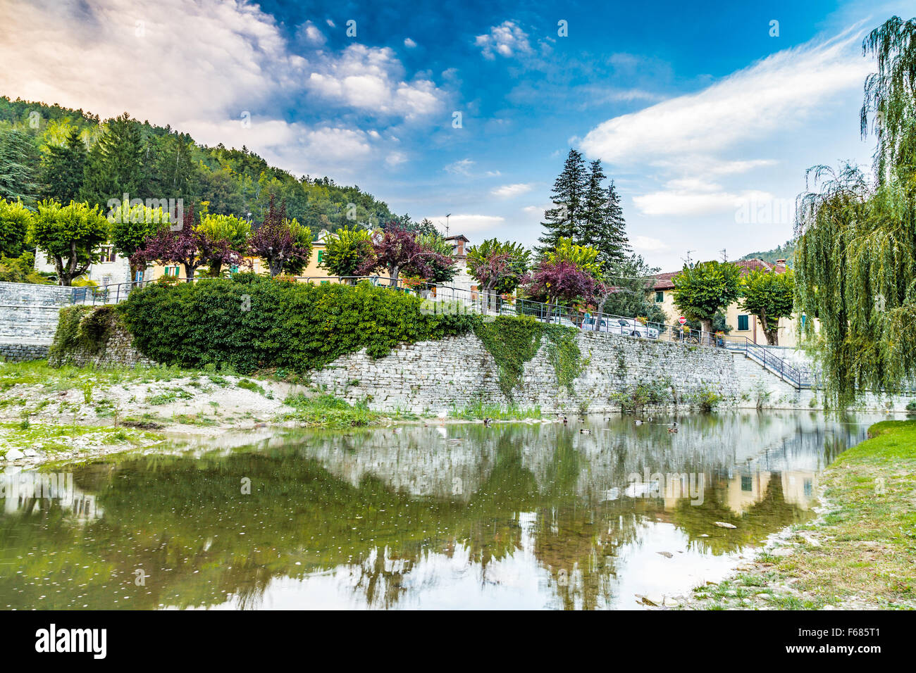 River runs thorugh medieval mountain village in Tuscany characterized ...