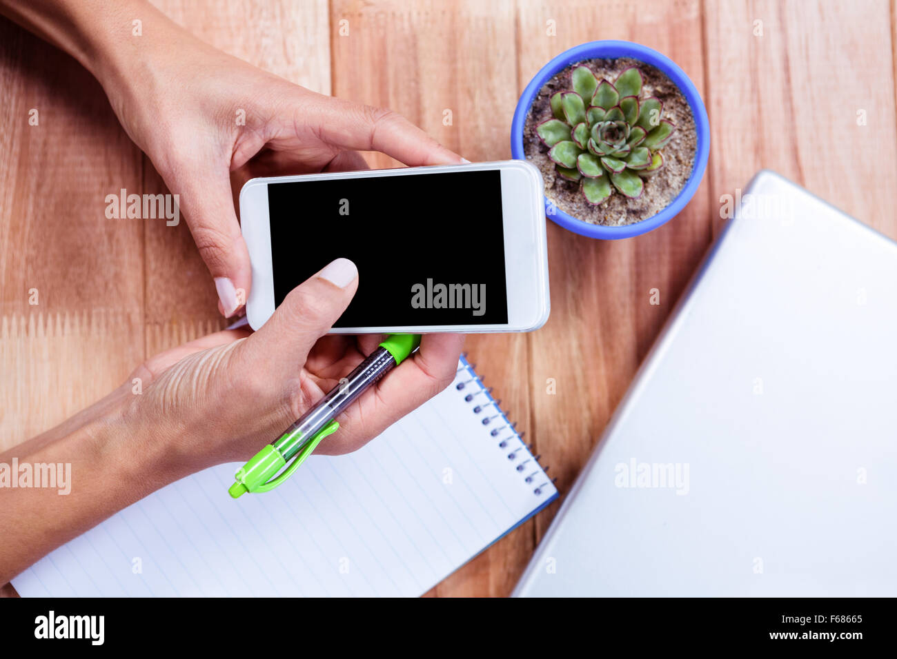 Feminine hands holding smartphone and taking notes Stock Photo - Alamy