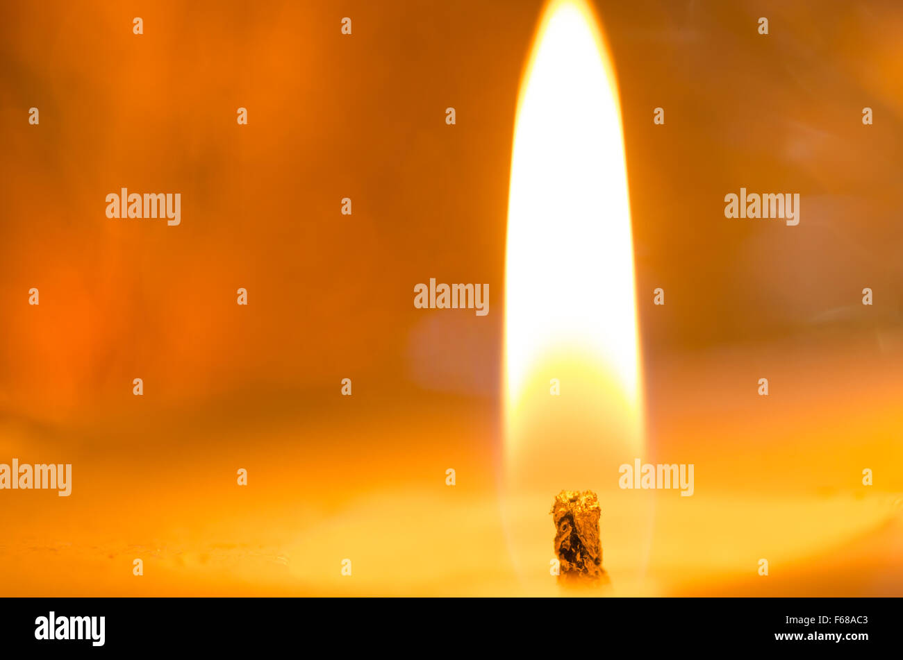macro of candle light on orange background Stock Photo - Alamy