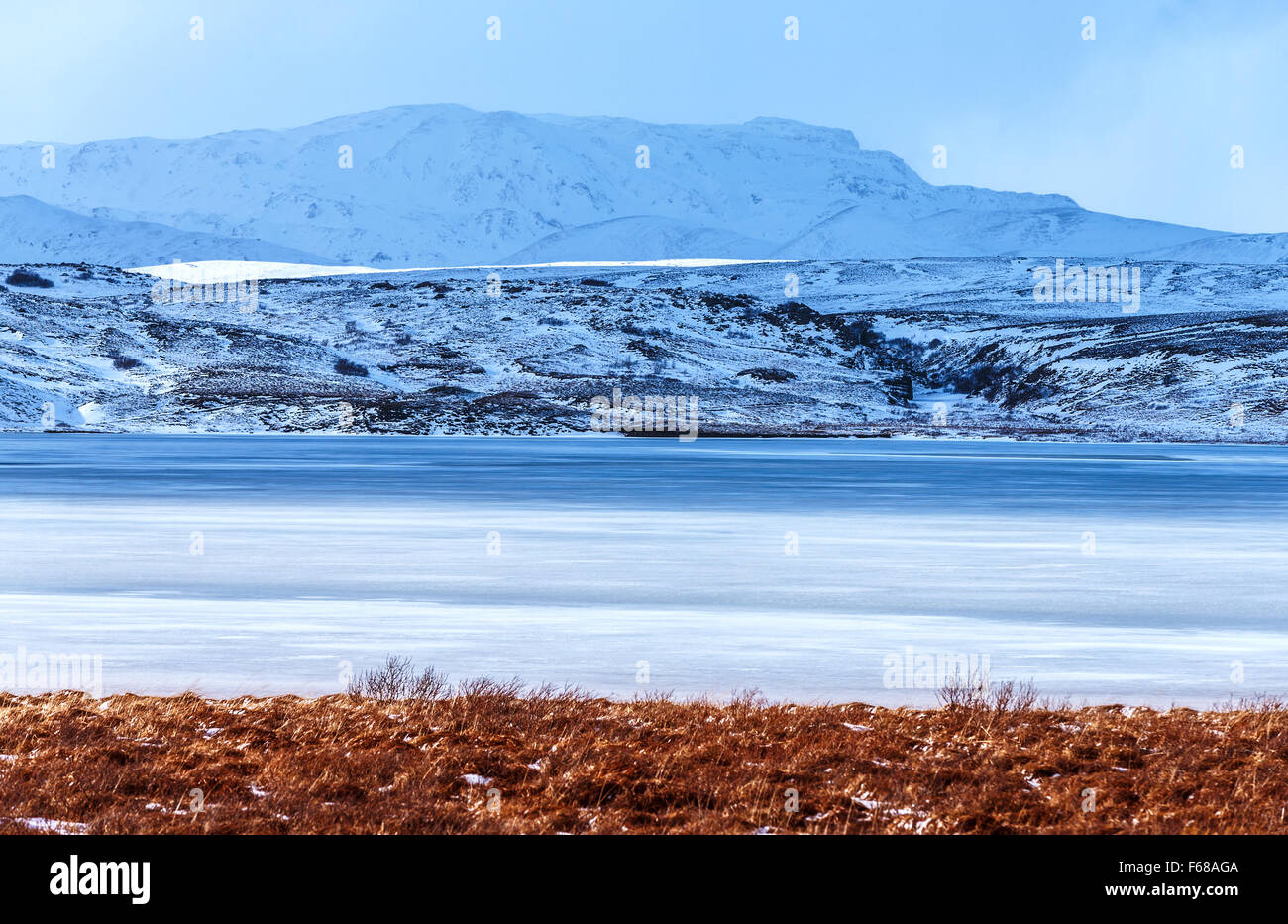 Beautiful winter landscape, big frozen lake near high mountains covered ...