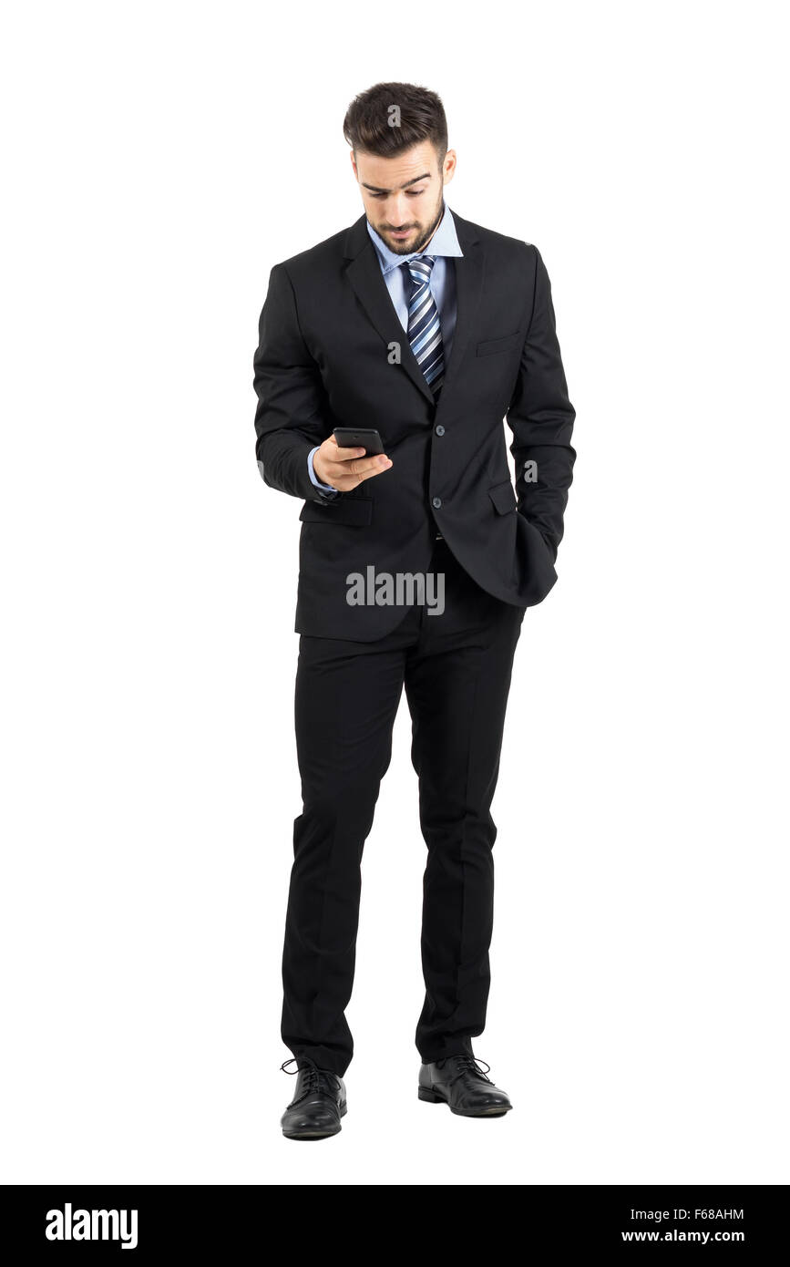 Young business man in suit reading message on his cellphone. Full body ...
