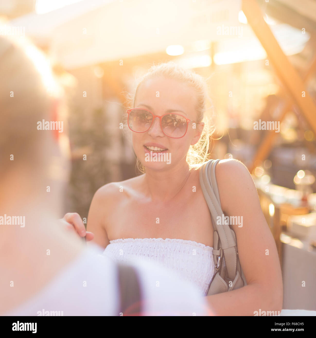 Female friends enjoying a conversation on market Stock Photo - Alamy