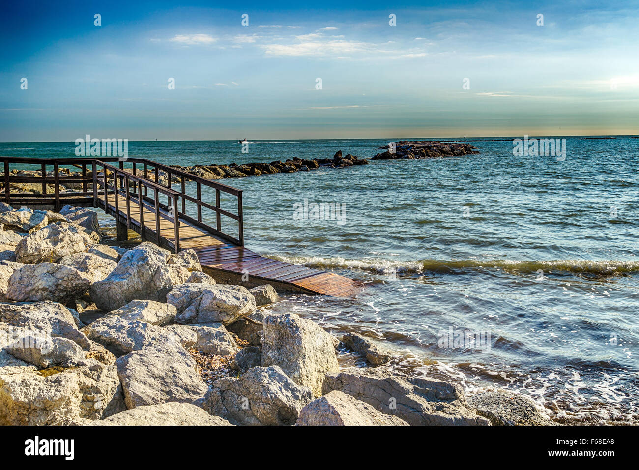 wooden footbridge with handrails and rocks in the Adriatic Sea Stock ...