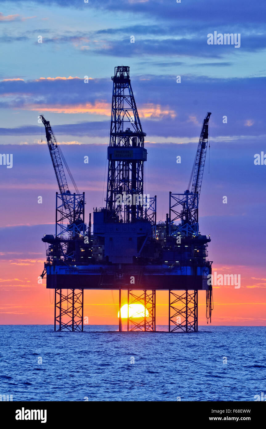 Sunset through an oil rigs legs Stock Photo - Alamy