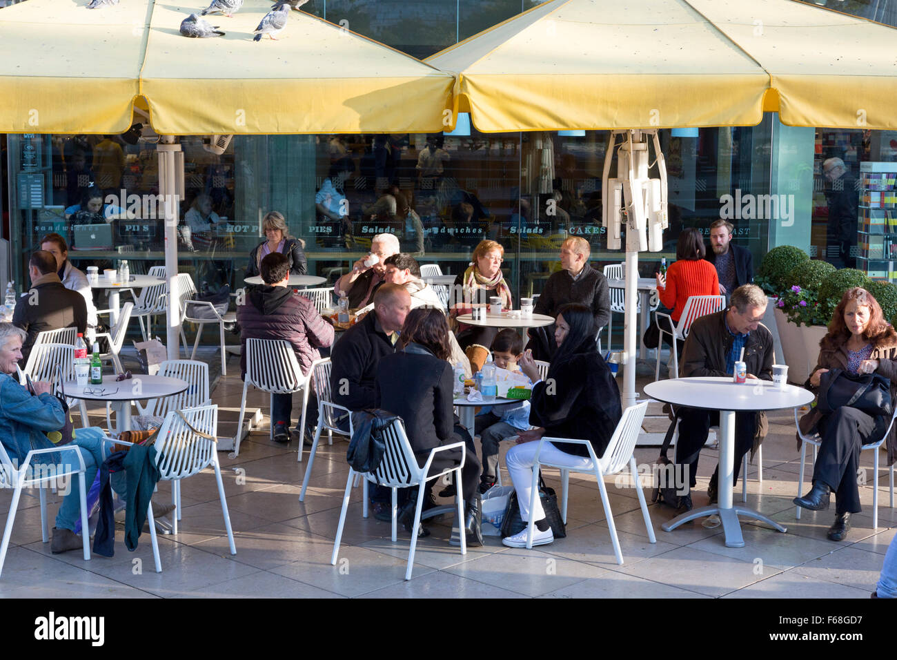 People sitting at tables outside EAT. restaurant, South Bank, London ...