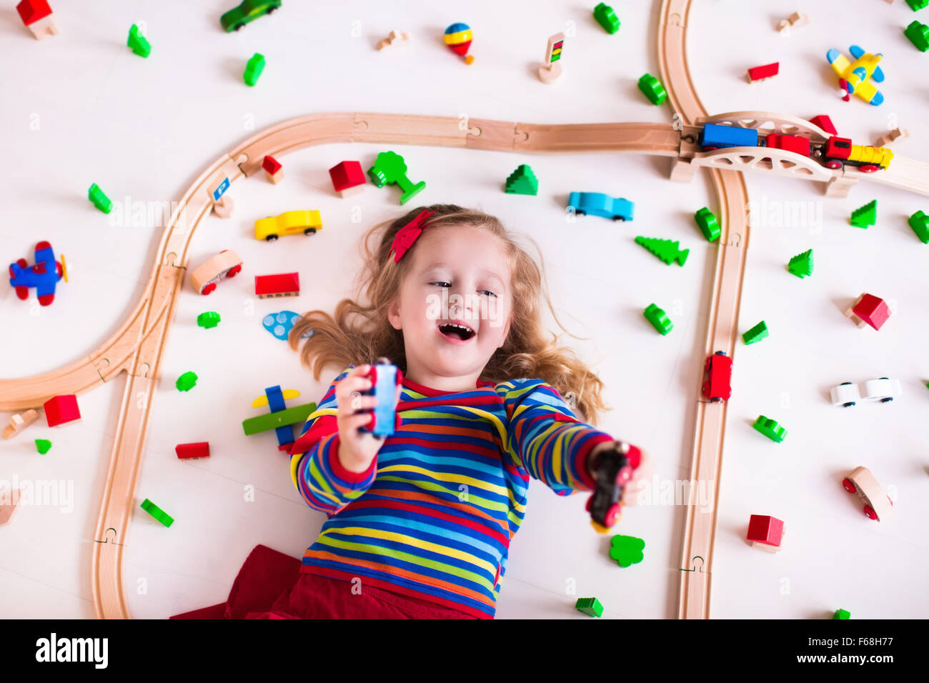 Child playing with wooden train, rails and cars. Toy railroad for kids ...