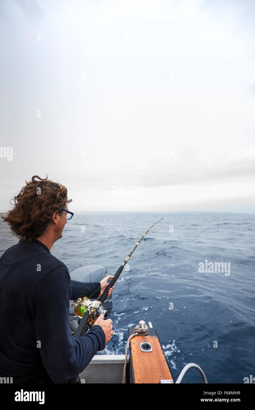 Man catches a fish in the ocean Stock Photo - Alamy