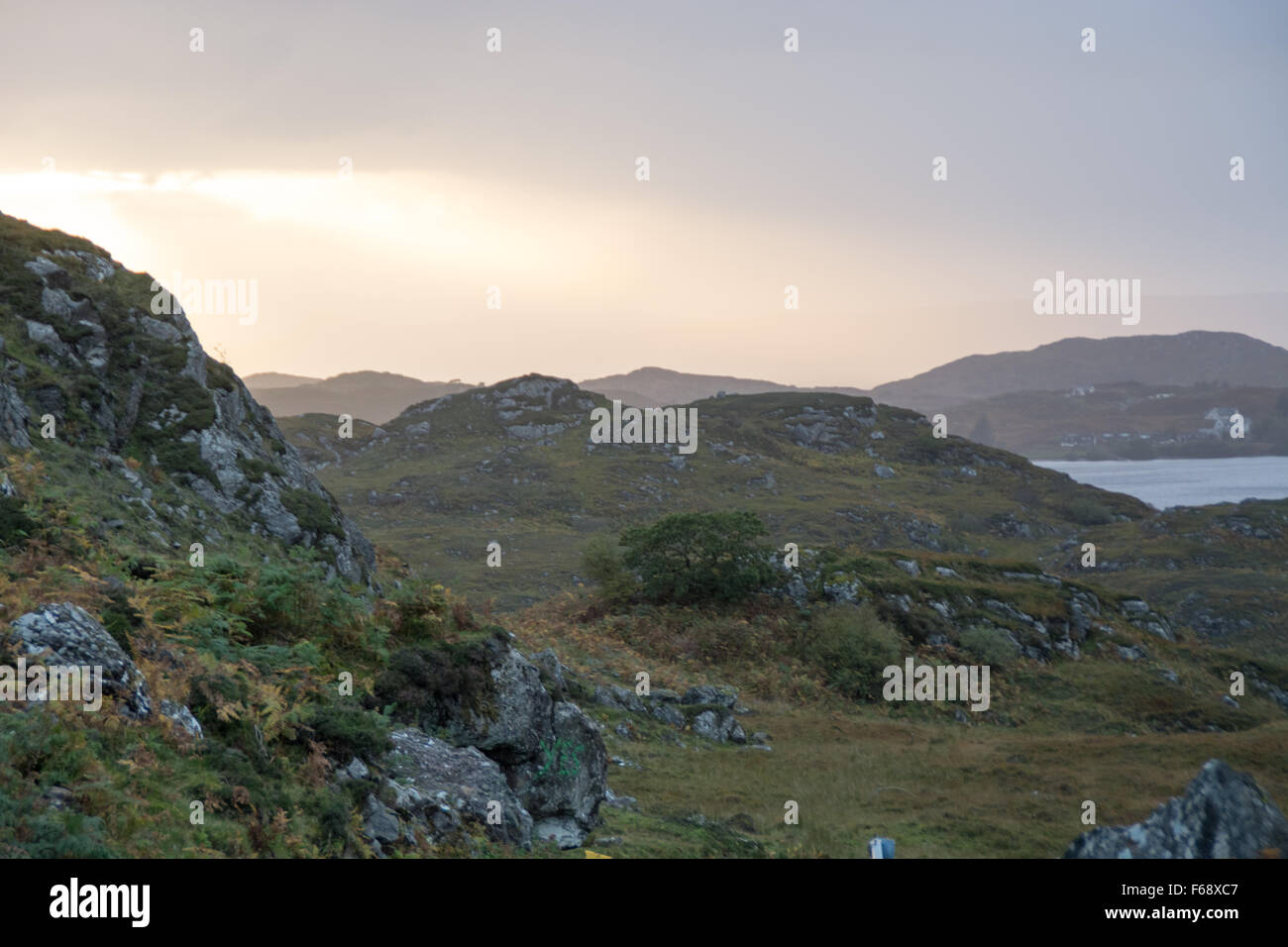 Rocky peaks around Loch Morar with sunshine piercing through the clouds ...