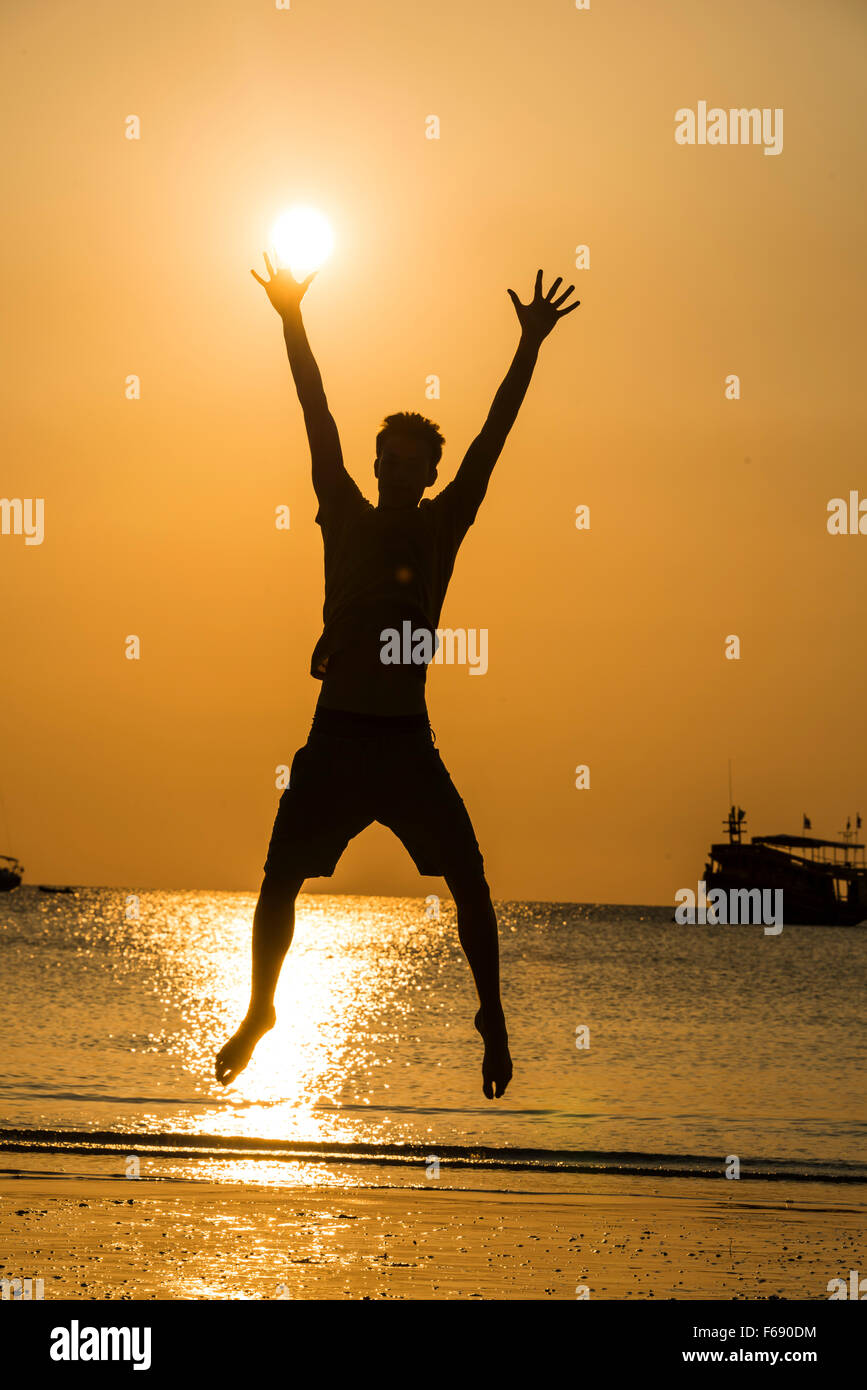Young man jumping on beach, silhouette, sunset, Koh Tao, Thailand Stock ...