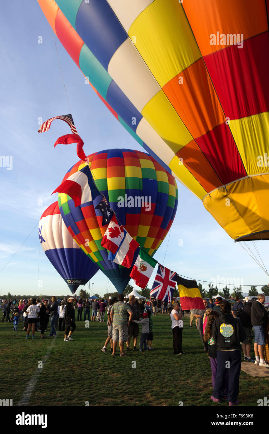 Three floating balloons still tethered to the ground as crowd wanders ...