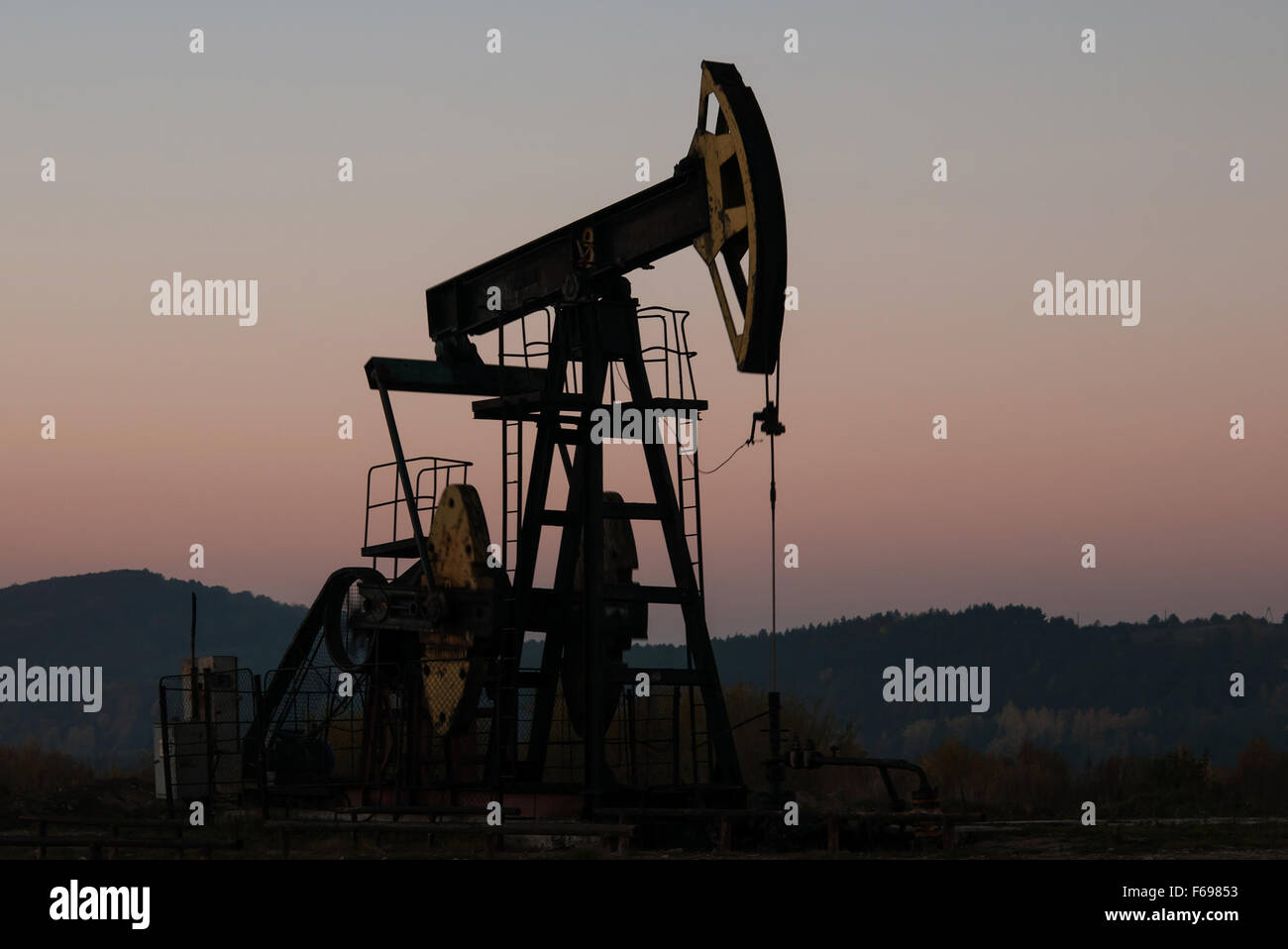 operating oil and gas well profiled on sunset sky Stock Photo - Alamy