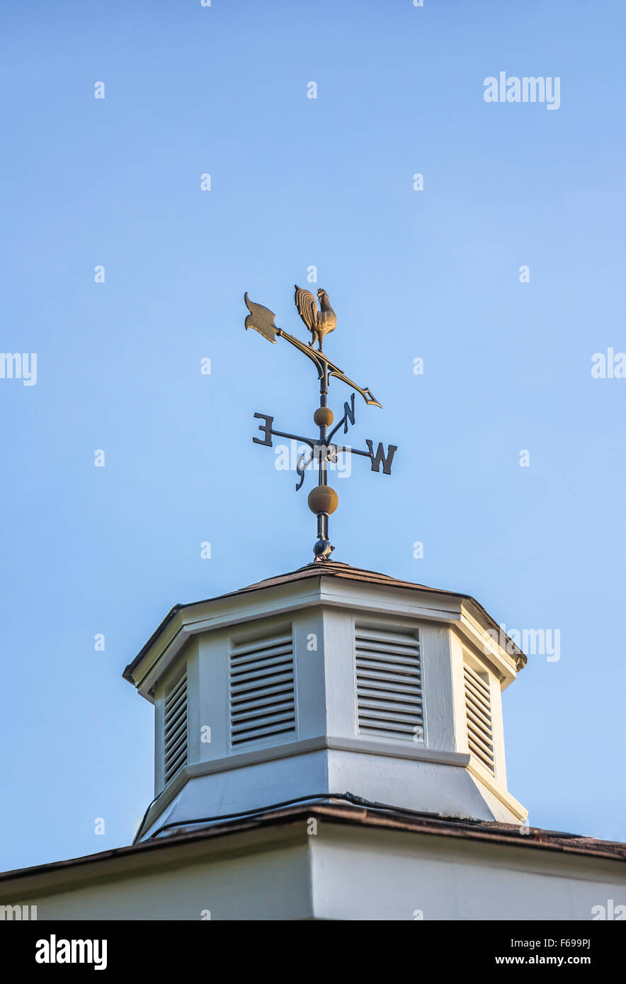 Rooster weather vane on a rooftop with an arrow and North-South pointer ...