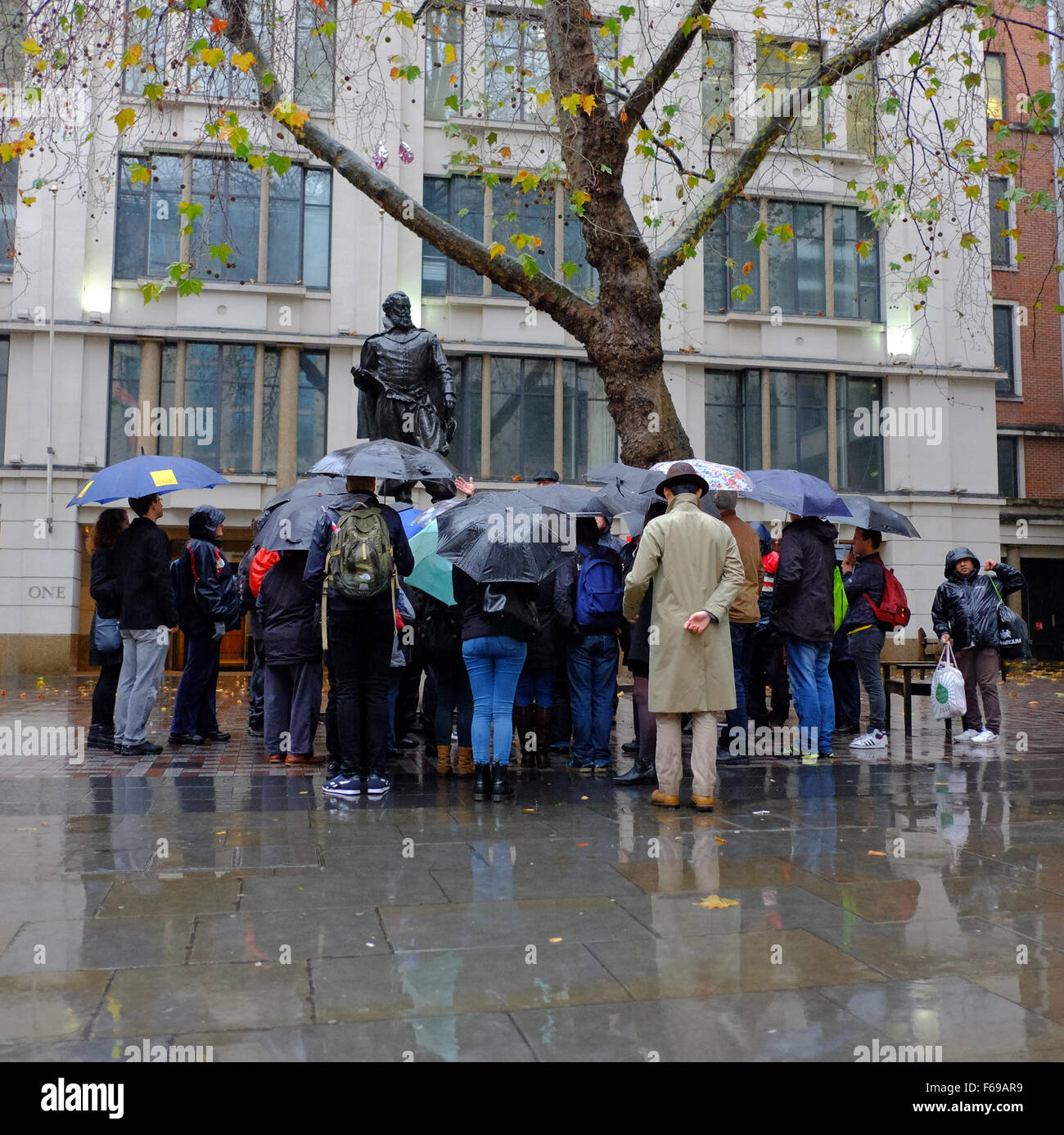 Tour guide and tourists with umbrellas in London Stock Photo - Alamy