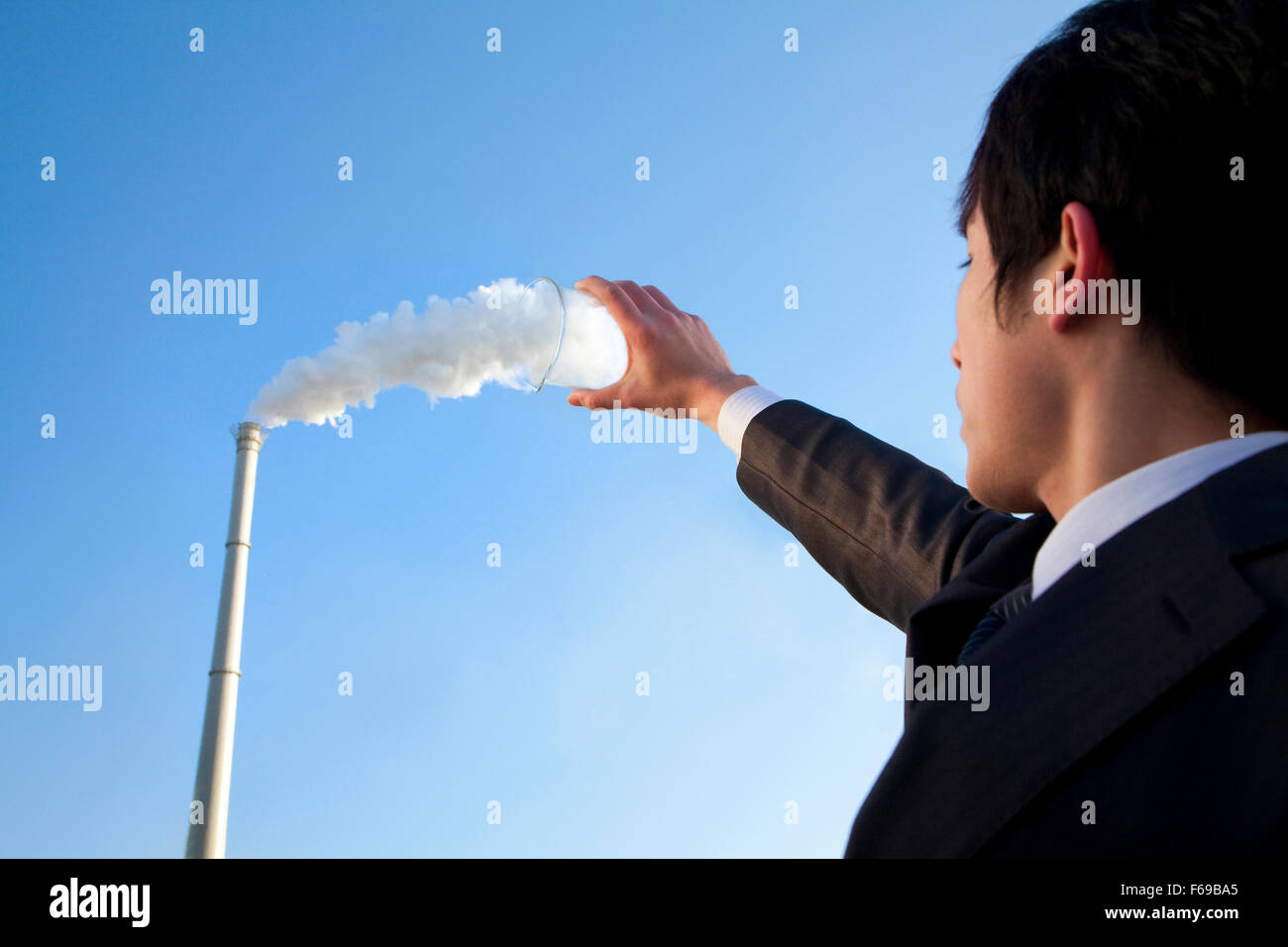 Businessman Collecting Smoke in Beaker Stock Photo - Alamy