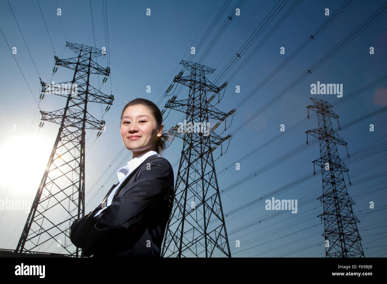 Businesswoman in front of power lines Stock Photo - Alamy