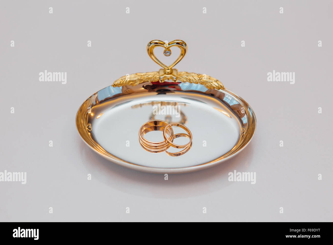 Golden wedding rings on a small plate Stock Photo - Alamy