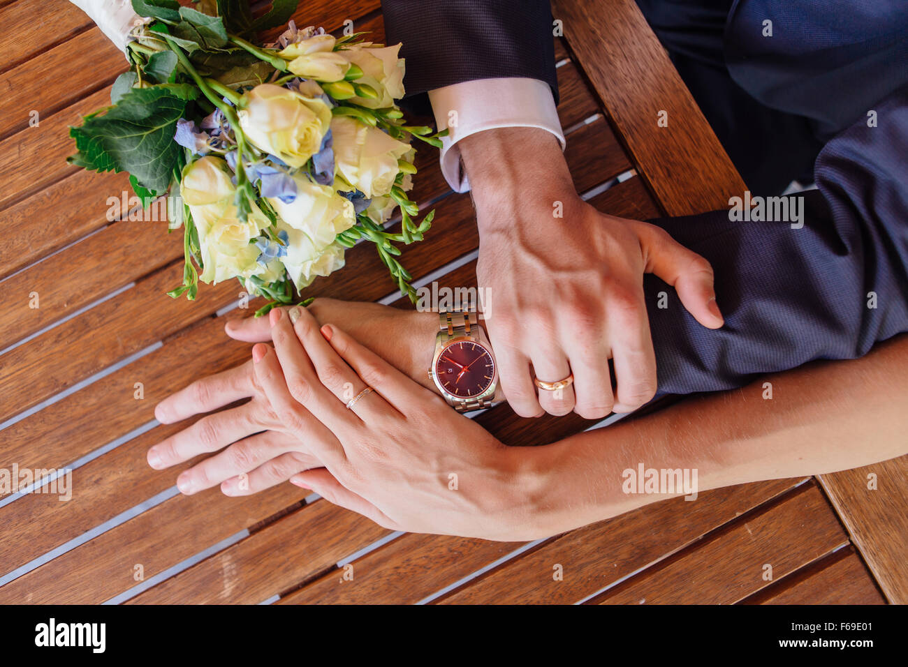 Hands of a man and a woman with wedding rings on the mans's wrist with ...