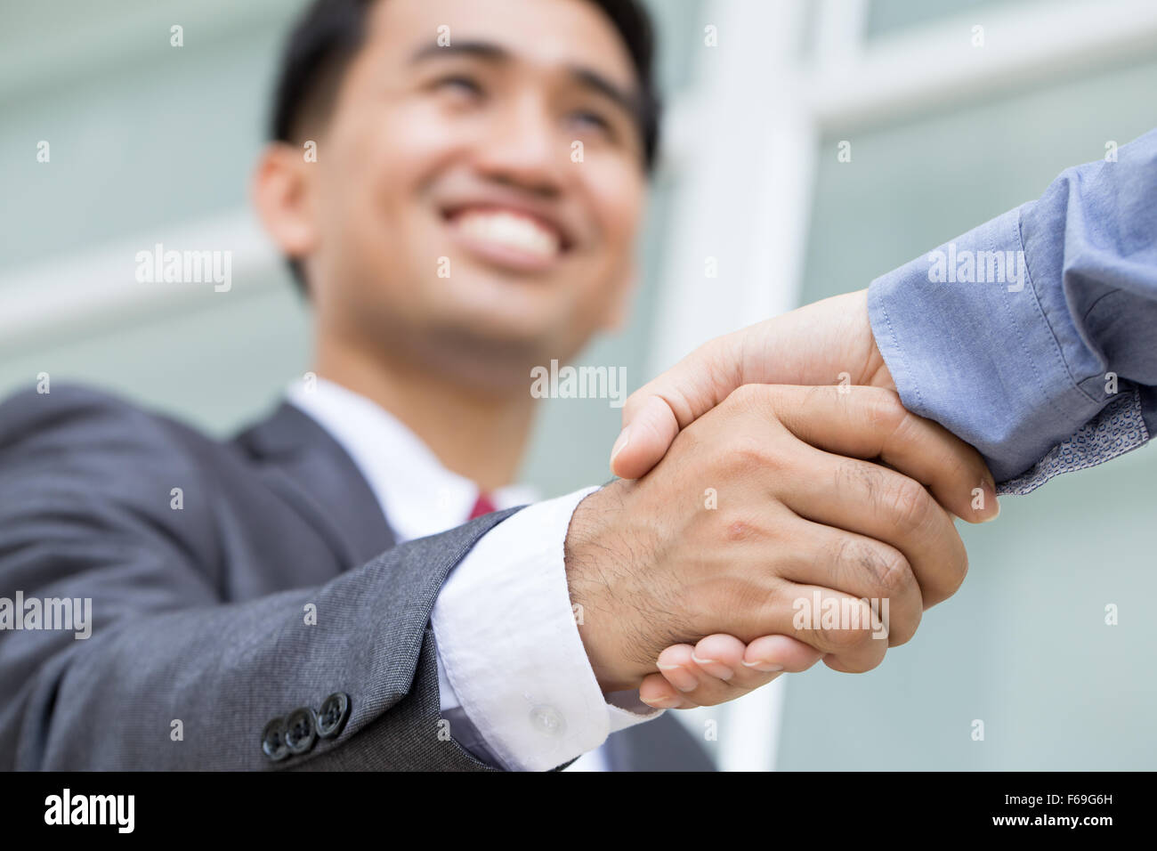 Asian businessman making handshake with smiling face Stock Photo - Alamy