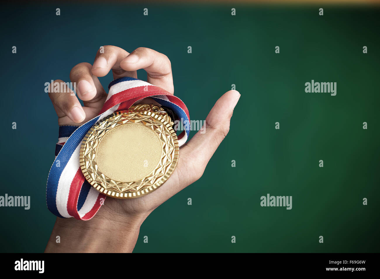 hand holding up a gold medal Stock Photo - Alamy
