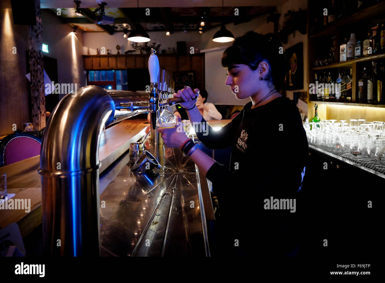 A young Christian Arab-Israeli female bartender pouring draft beer in ...
