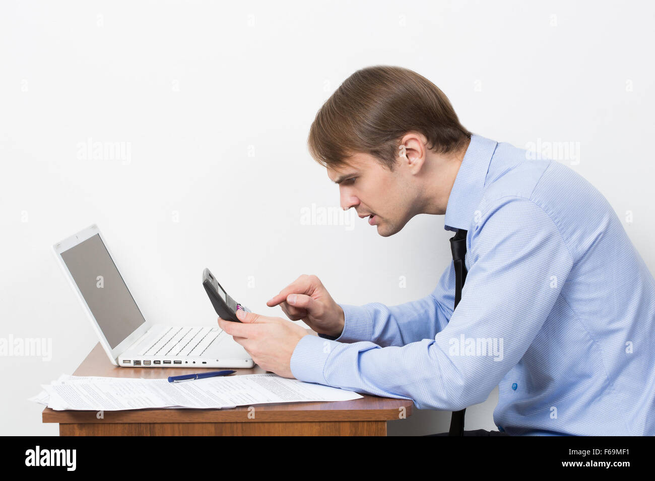 man with a calculator at his desk in the office Stock Photo - Alamy
