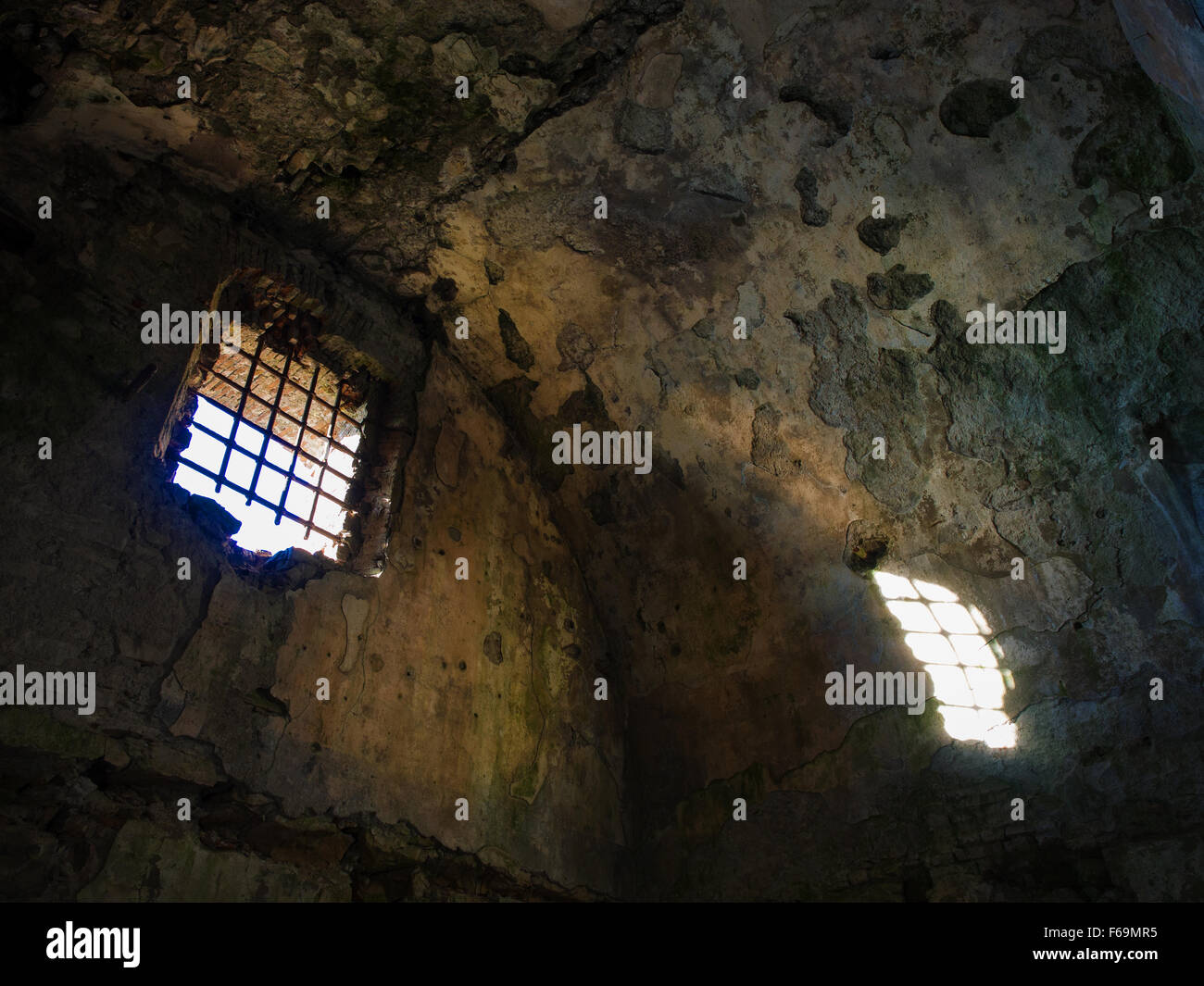 ruined prison jail of a medieval castle. sunlight enters from a window ...