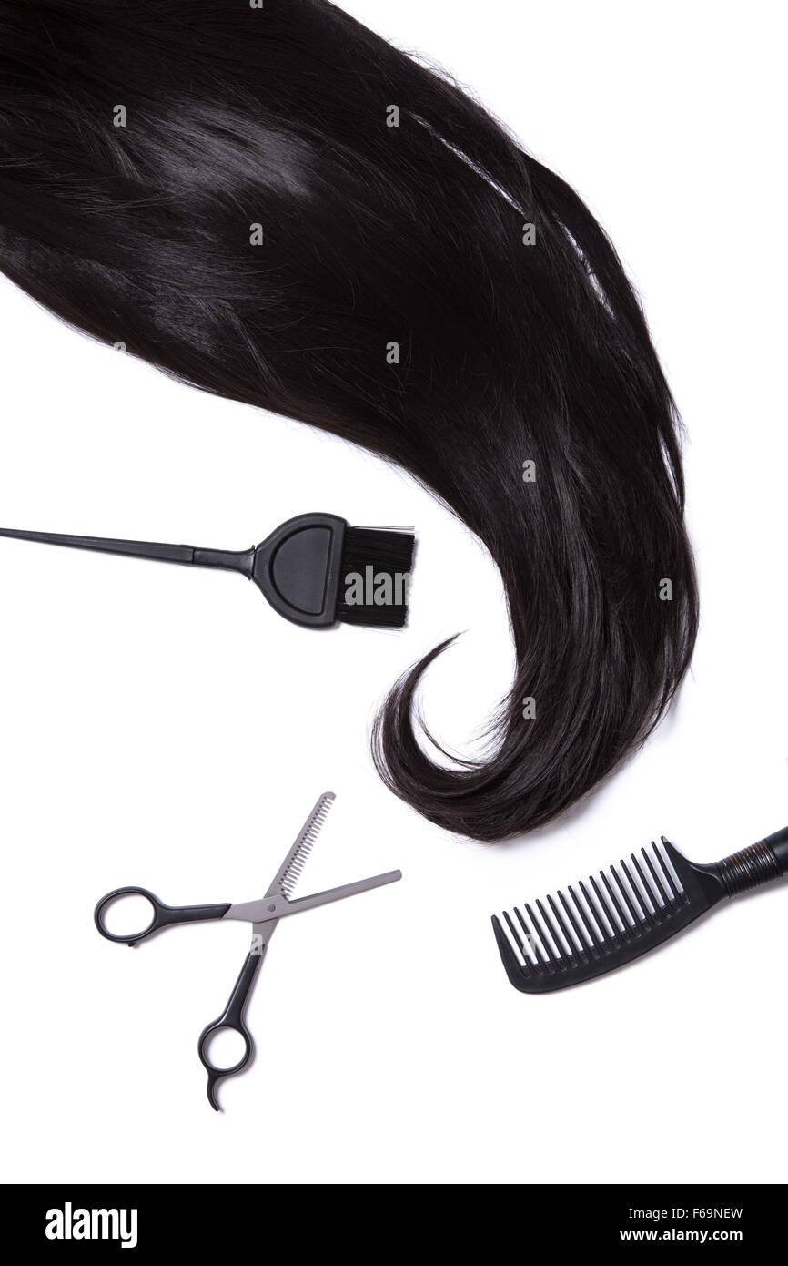 Black silky hair, hair dye brush, scissors, and hairbrush, isolated on ...
