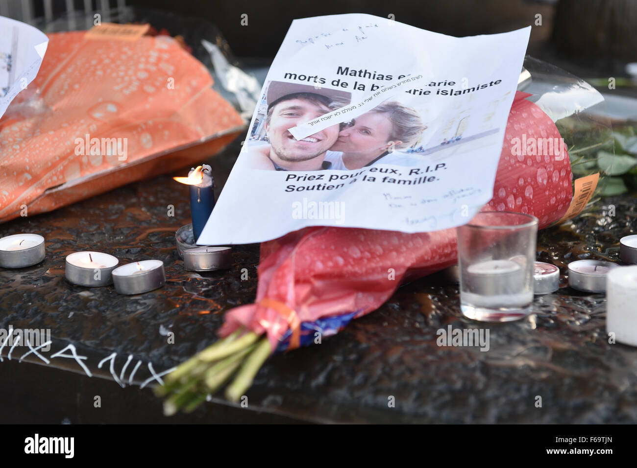 A picture of two victims lays on a bunch of flowers at the Place de la ...