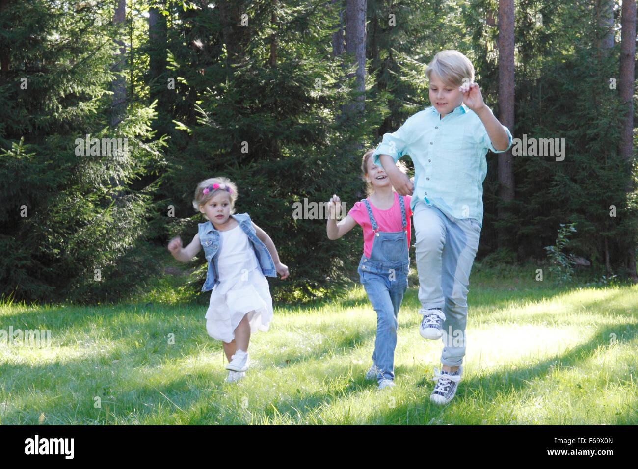 Group of young children running towards camera in park Stock Photo - Alamy