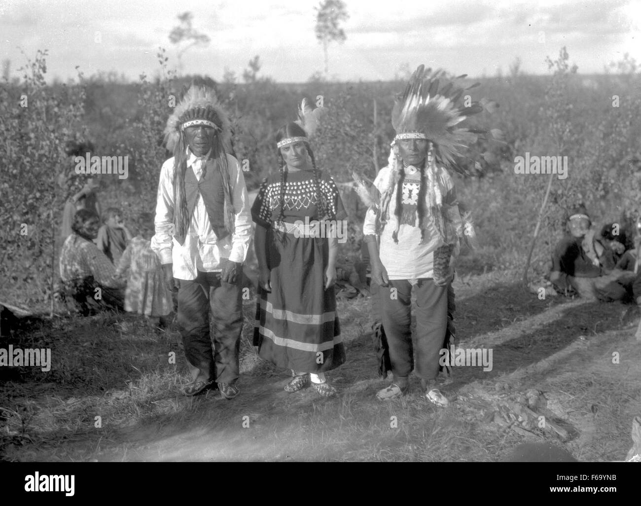 A photograph depicting a young Cree woman standing between two elders ...