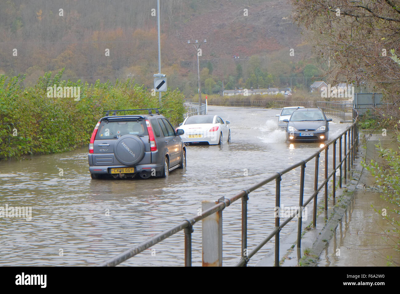 Cars driving through flooded road after torrential and prolonged ...