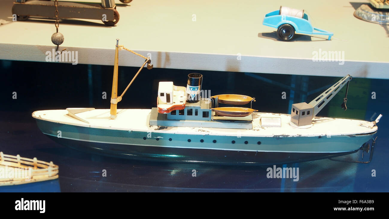 A vintage clockwork wind-up tin toy with an old trailer on display at ...