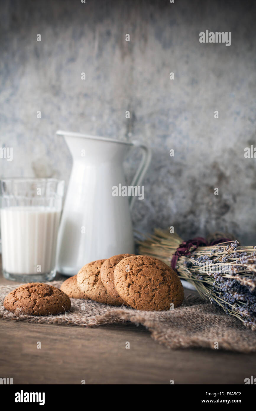 Chocolate chip oatmeal cookies, dried lavender and milk on linen rag ...