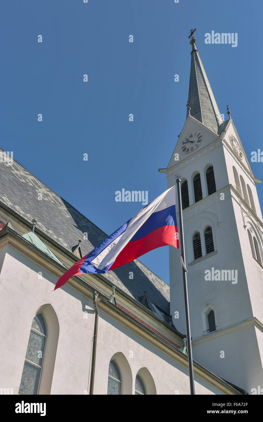 National flag and Neo Gothic Parish Church of Saint Martin at Bled lake ...
