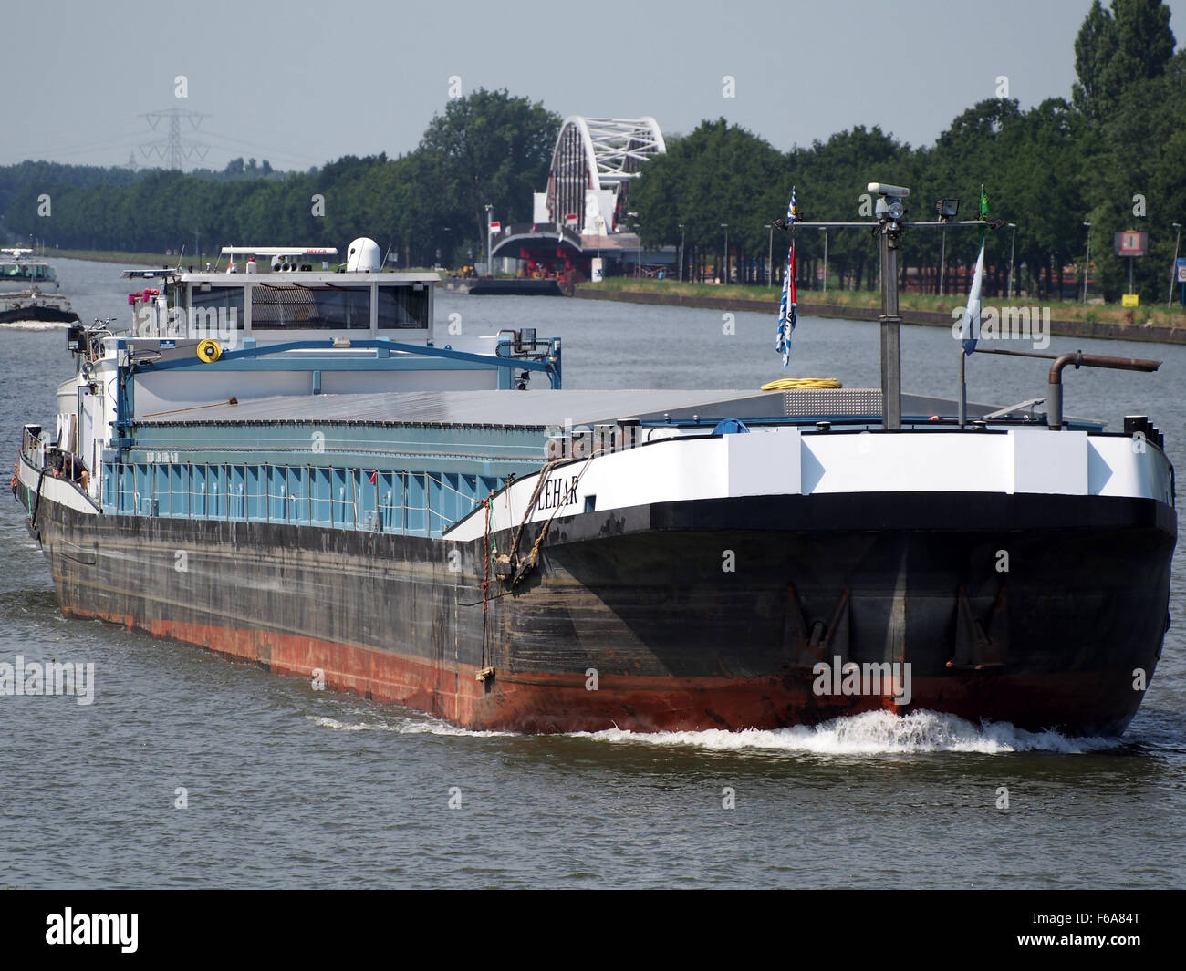 The image depicts a container ship navigating the Amsterdam-Rijn Canal ...