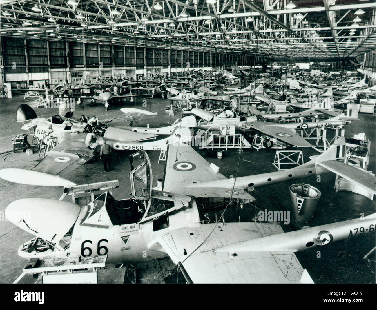 The 1955 image shows the assembly line of the *Vampire Trainer*, an ...