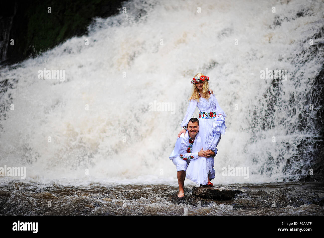 Young beautiful couple in traditional dress near waterfall Stock Photo ...