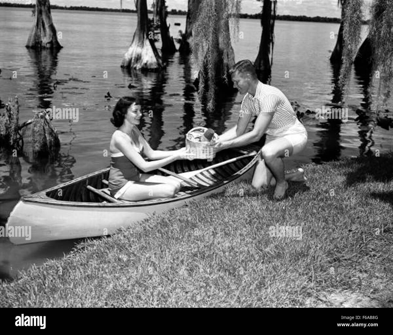 A photo showing a group of people enjoying a picnic and canoe trip in ...