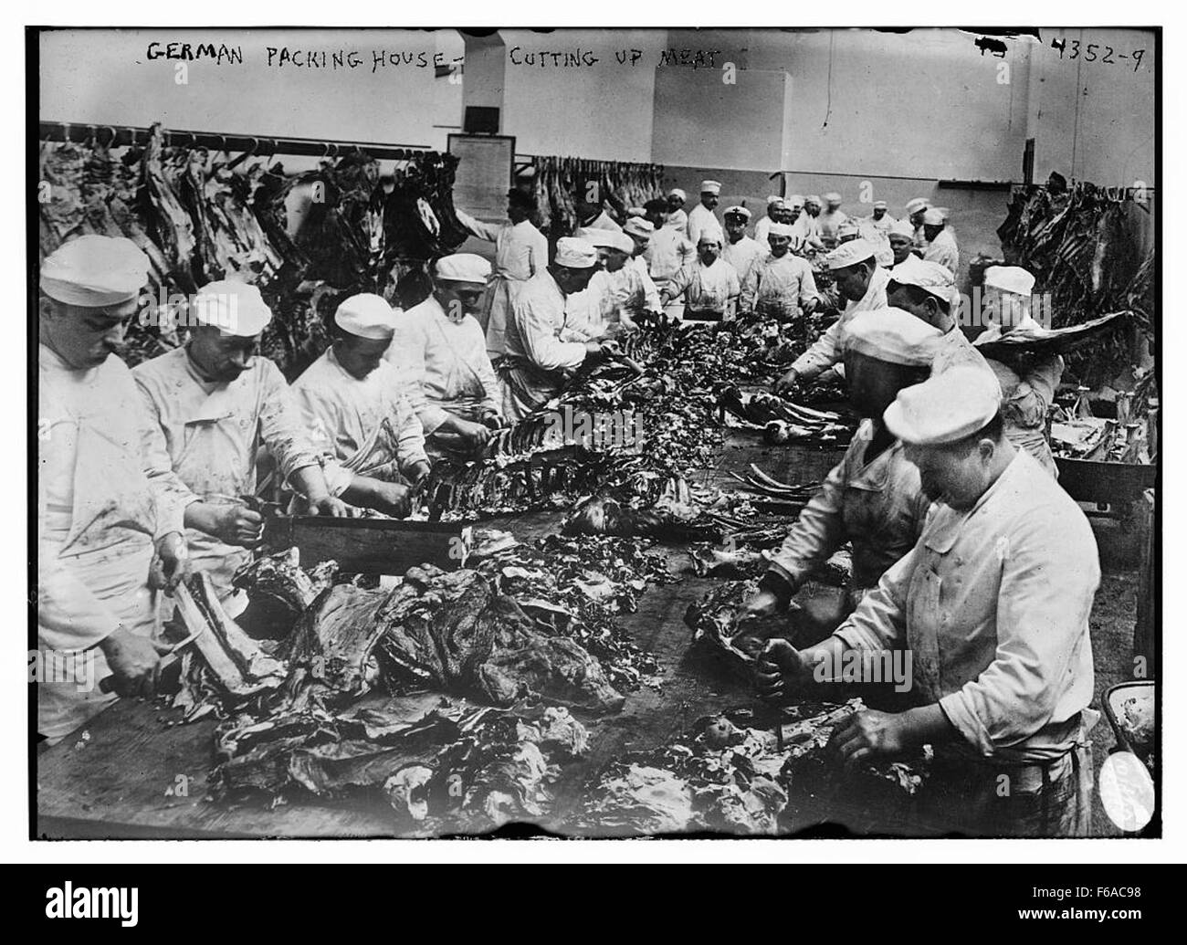 This photograph depicts a German packing house where workers are ...