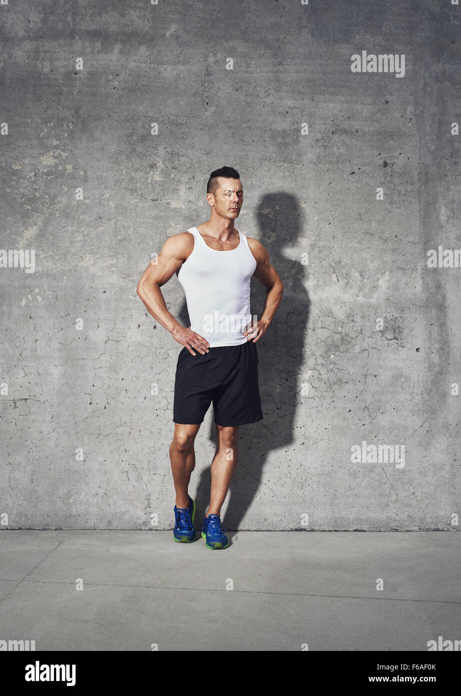 Full body fitness portrait of muscular man, standing with both hands on ...