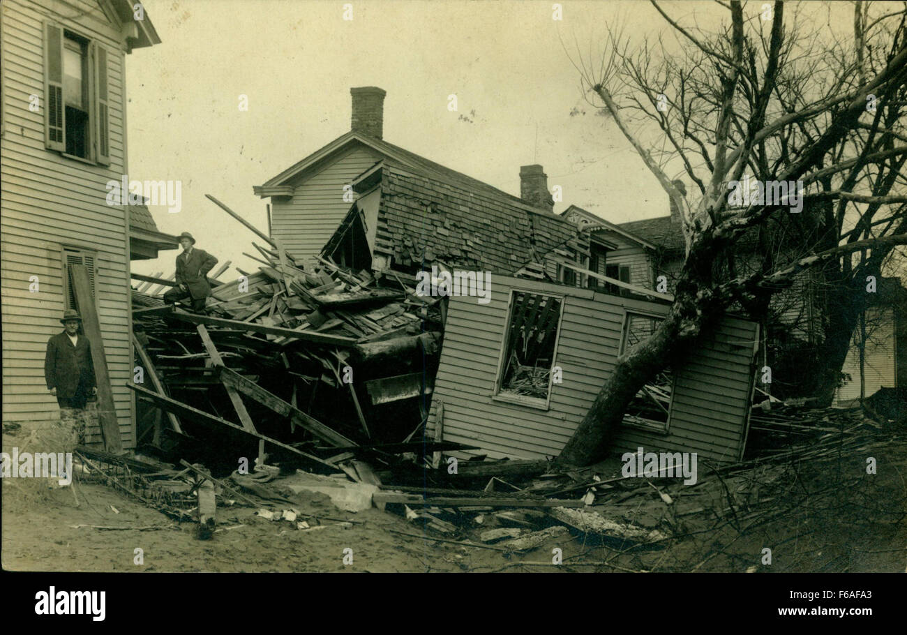 This image depicts a destroyed house with a large sycamore tree in the ...