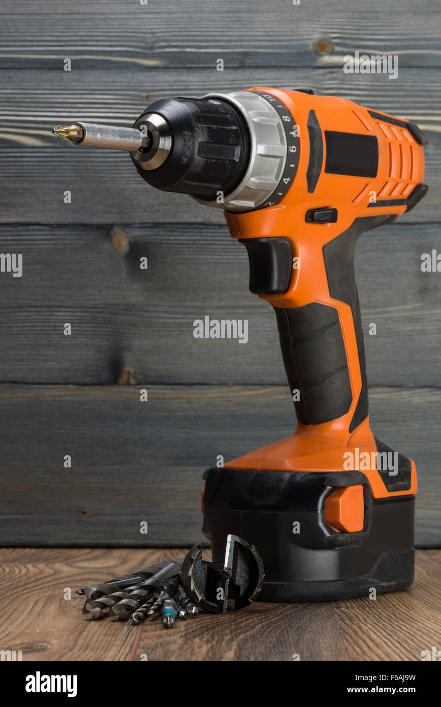 battery powered drill and drill on a wooden surface Stock Photo - Alamy