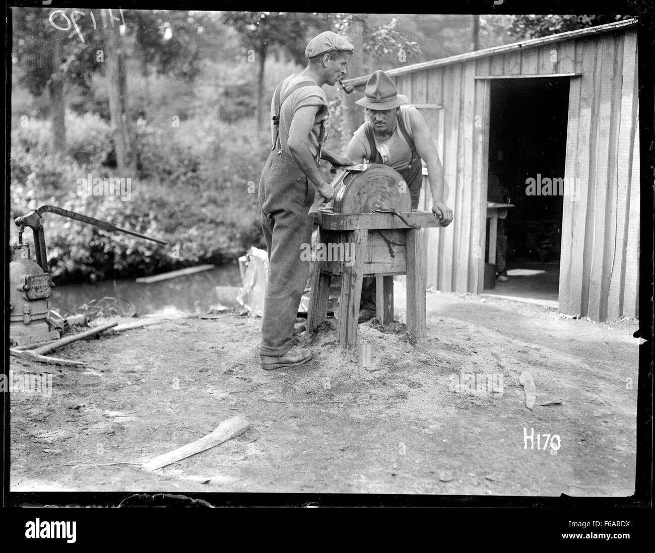 This historical image shows soldiers sharpening axes for forestry work ...