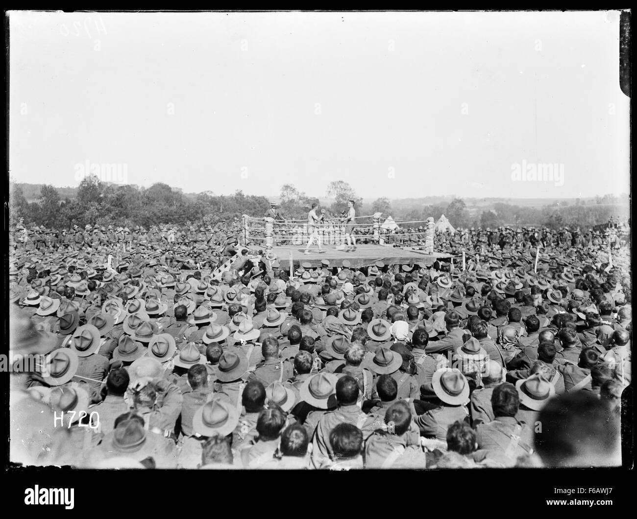 This historic photograph captures a crowd of soldiers watching a boxing ...
